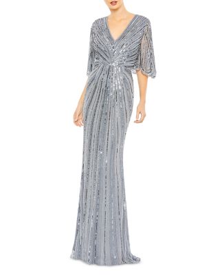 Click here for Mac Duggal Sequined V Neck Cape Sleeve Column Gown prices